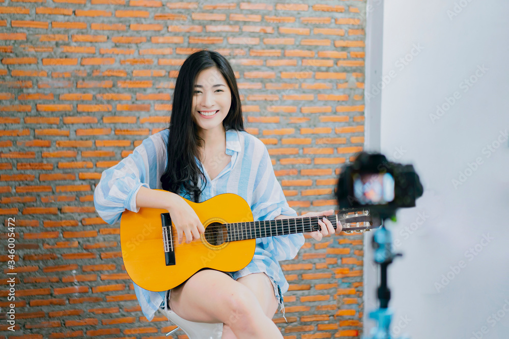 Asian female musician performing live in front of audience recording ...