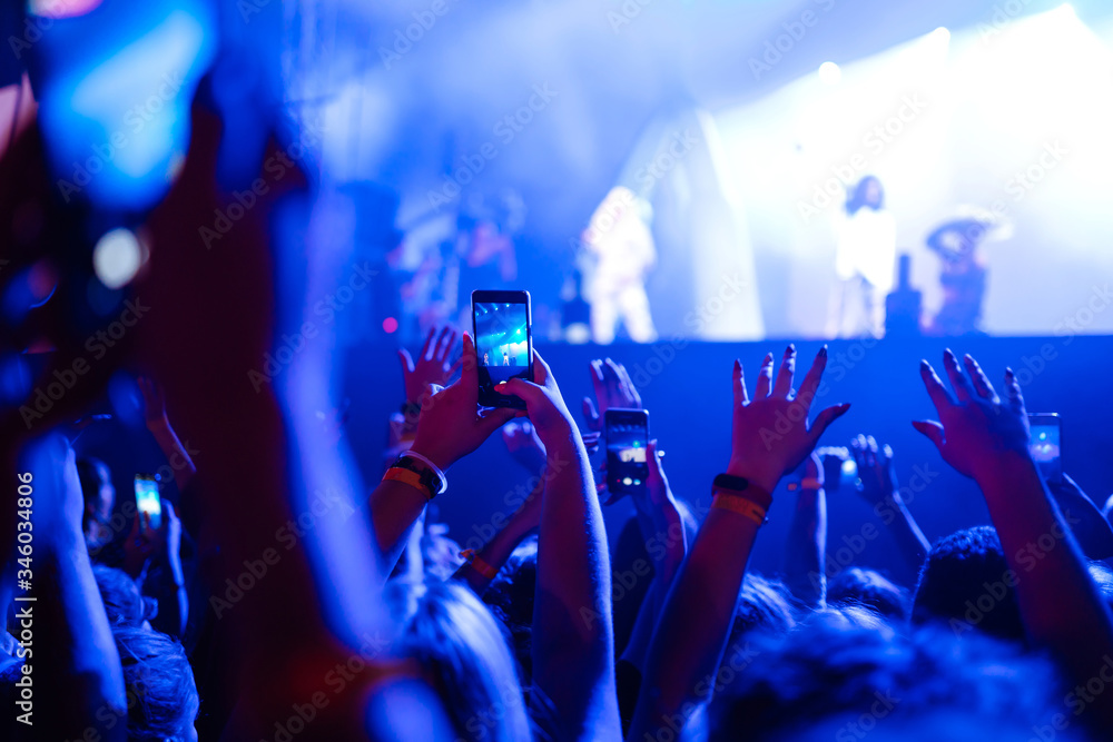 People taking photographs with smart phone during a music festival ...