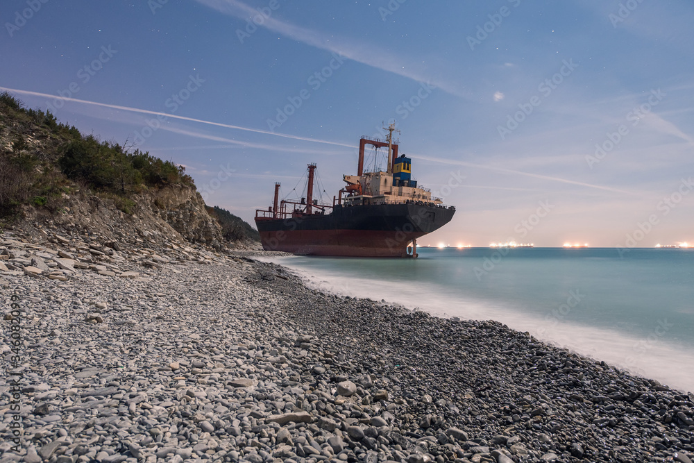 Abandoned broken ship ran aground on shore after storm. Ship graveyard ...