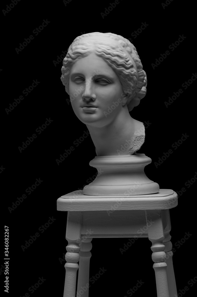 Gypsum copy of ancient white statue of bust of Venus on chair with ...