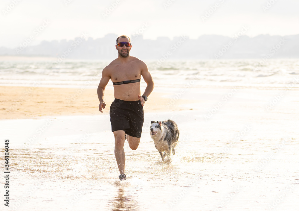 Sport man running with dogs and workout with heart rate monitor on dog ...