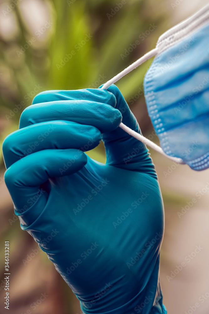 Male hands wearing medical gloves and putting on a face mask. Surgical ...