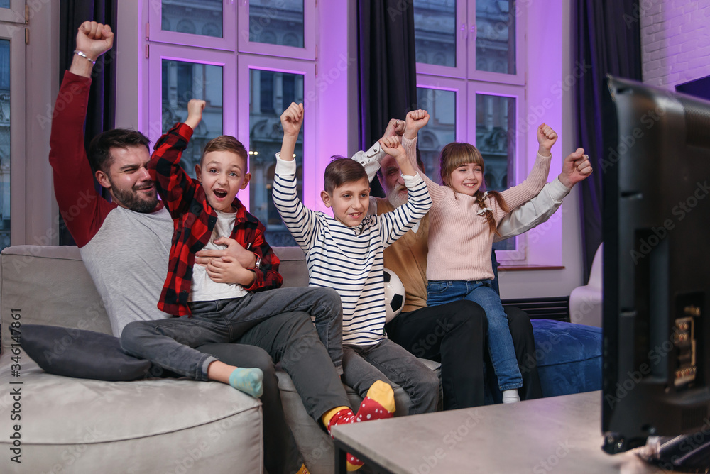 Family watching american football match, championship on the couch at ...