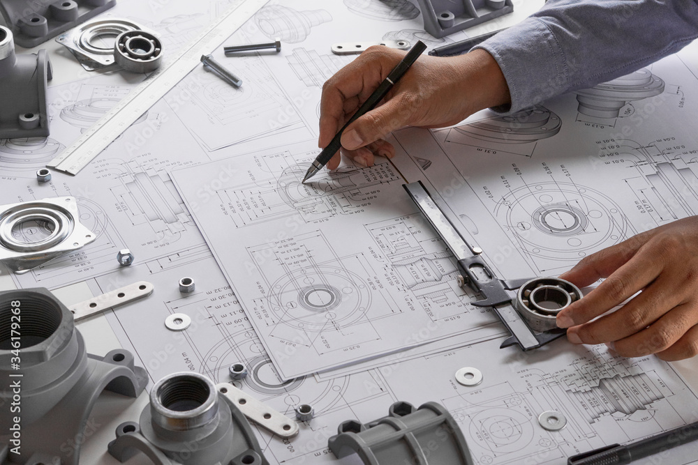 Foto de Engineer technician designing drawings mechanical parts ...