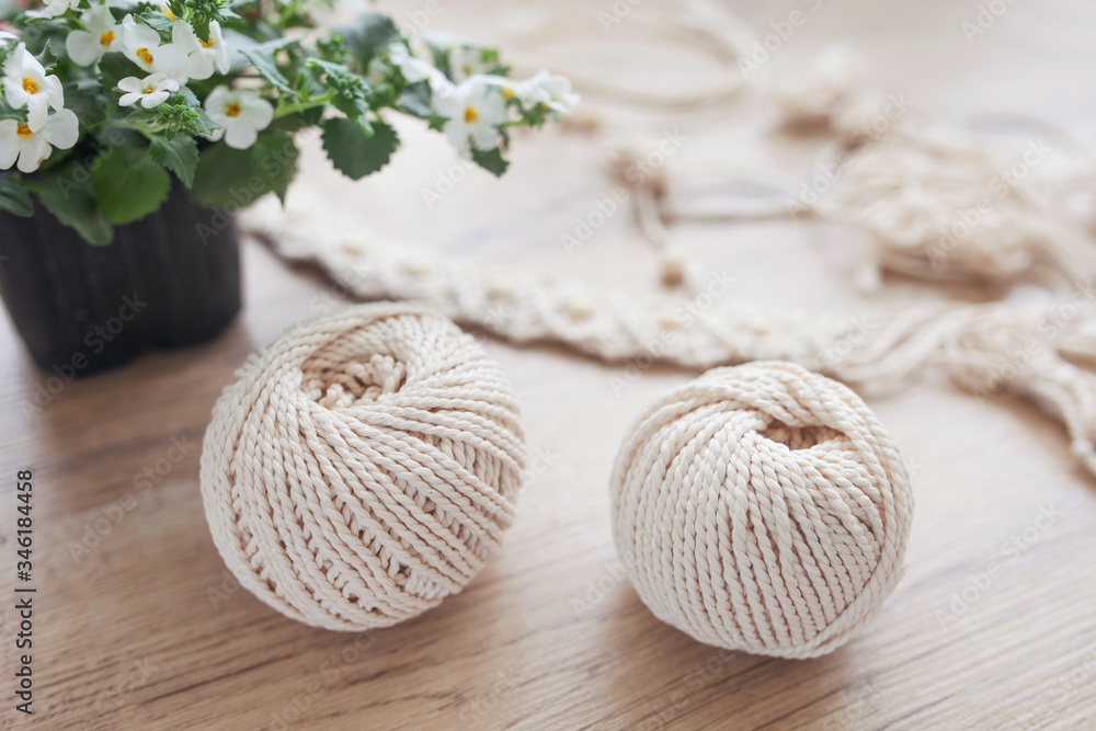 Handmade macrame braiding and cotton threads on rustic wooden stick ...
