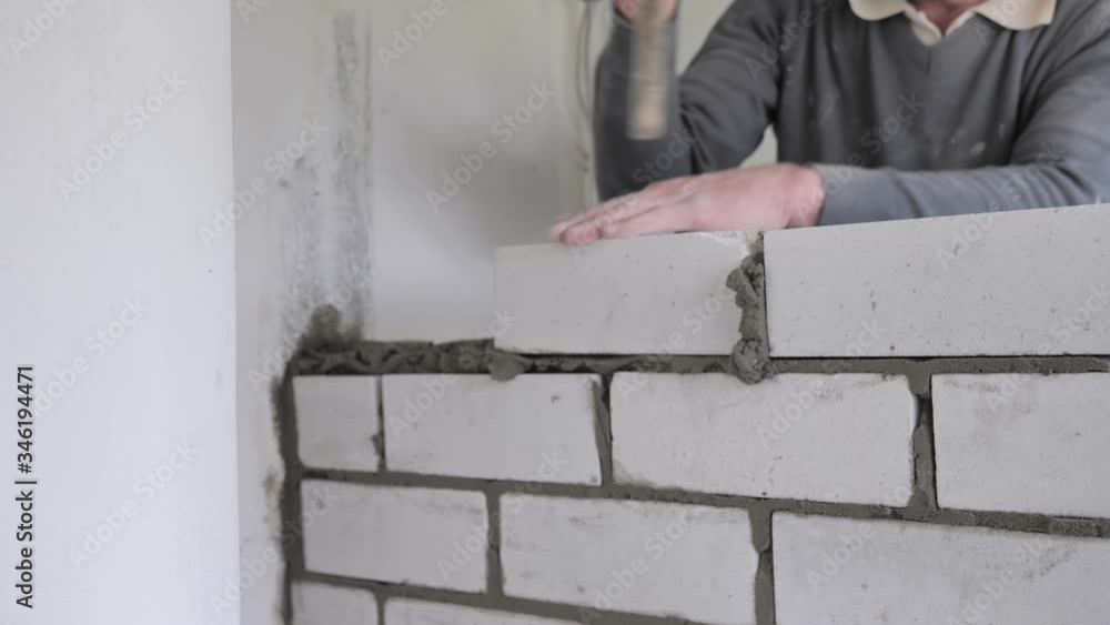builder hands, the man puts the bricks on concrete. Male builder laying ...