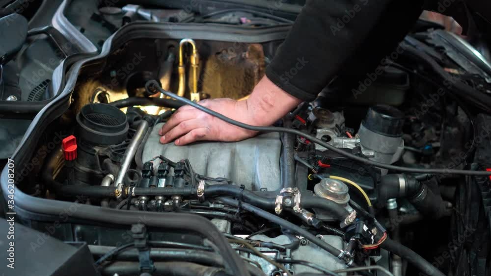 Repairing the car engine. A service station. The repairman inspects the ...