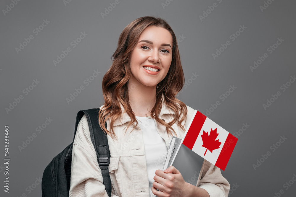 Young girl student smiling and holding a small canada flag isolated on ...