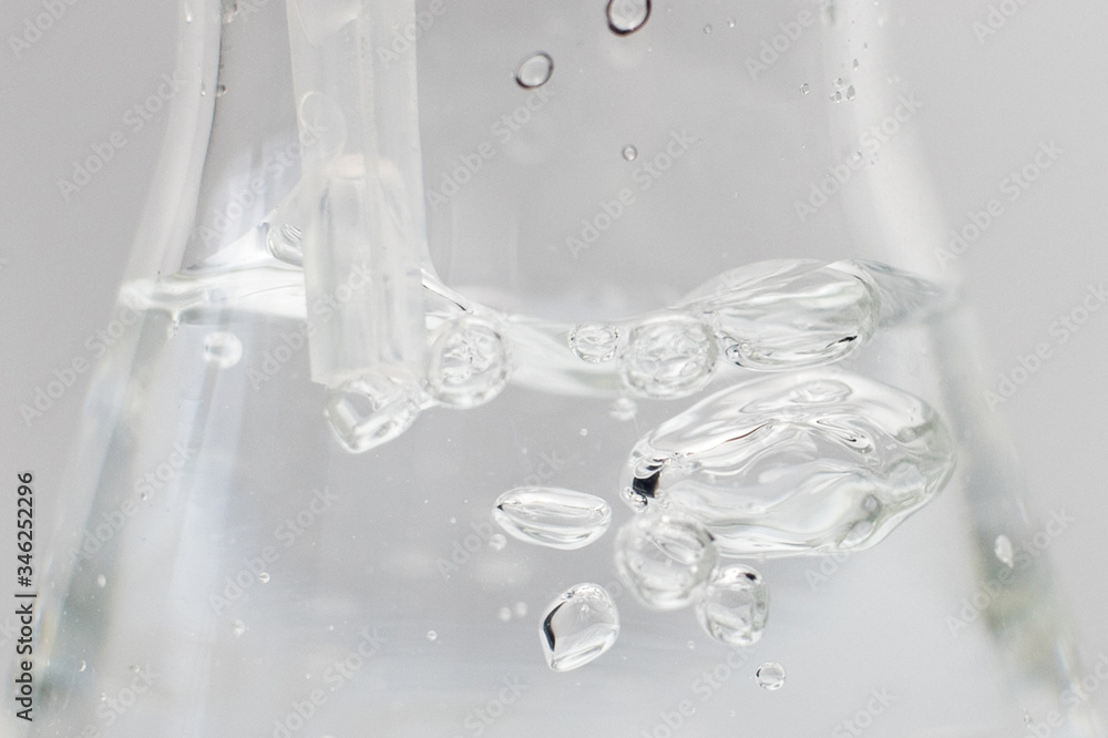 Closeup of a liquid with bubbles in a glass erlenmeyer flask with a ...