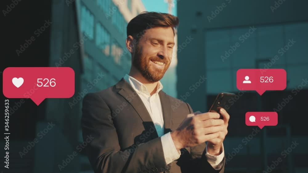 Happy handsome young man uses smartphone typing social media icons with ...