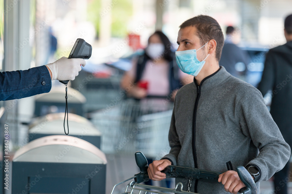 Temperature check at a supermarket of man, grocery store with thermal ...