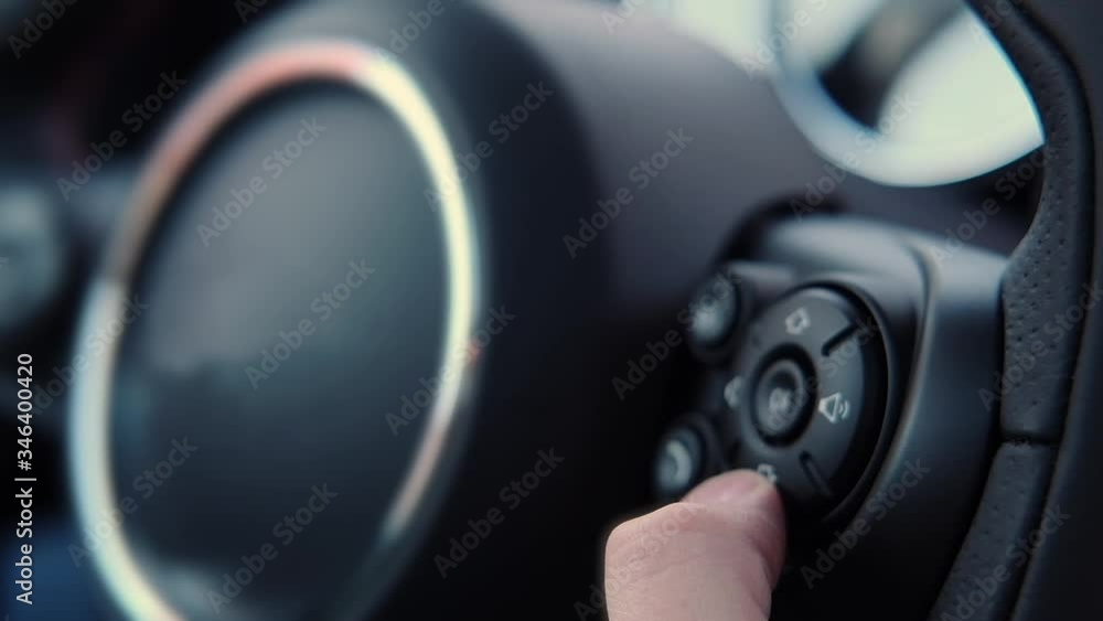 Close-up of the finger of a male driver who, with the help of shortcuts ...