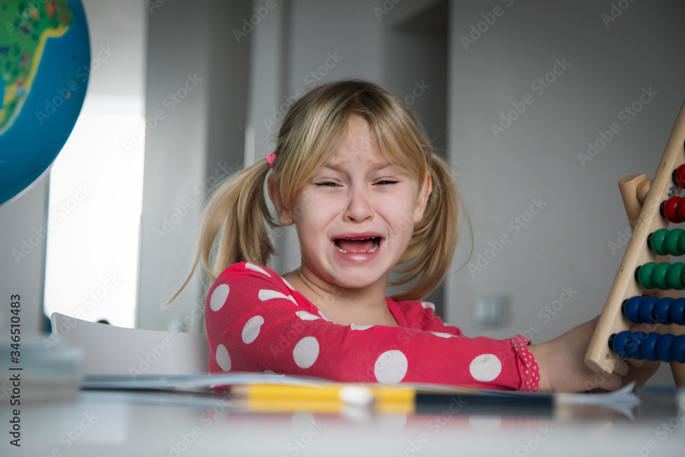 sad crying child doing homework indoors, mental issues of staying home ...