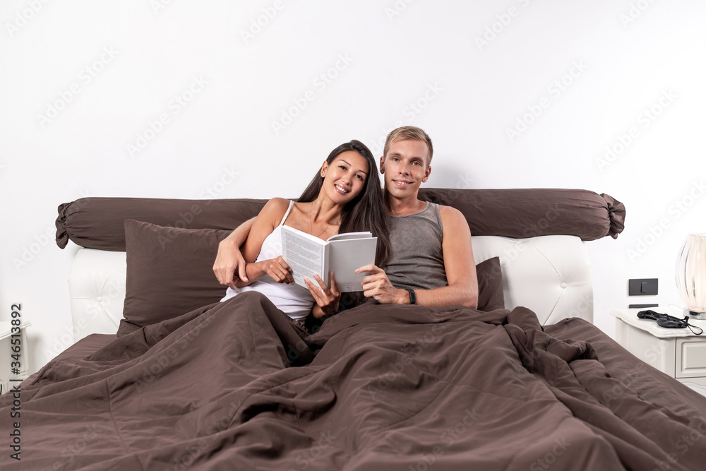 A lovely, sweet, smiling couple of lovers loves to read a book together ...