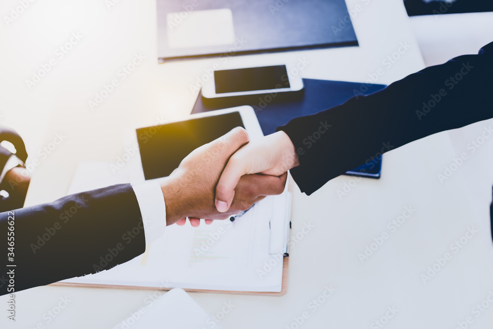 Business partners handshake over office table during negotiation and ...
