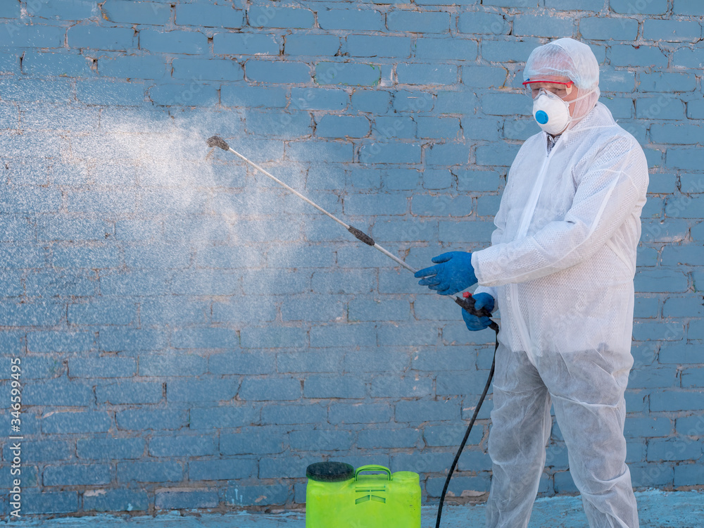 man in white protective clothing with glasses and medical mask is ...