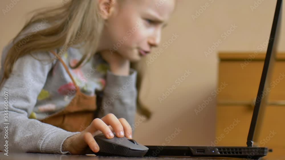 Little child hand is holding a computer mouse on laptop screen ...