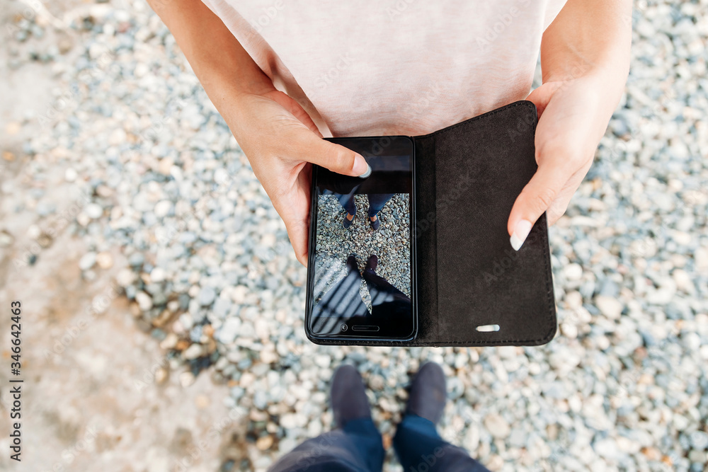 Couple taking picture of their feet on the beach using mobile camera ...