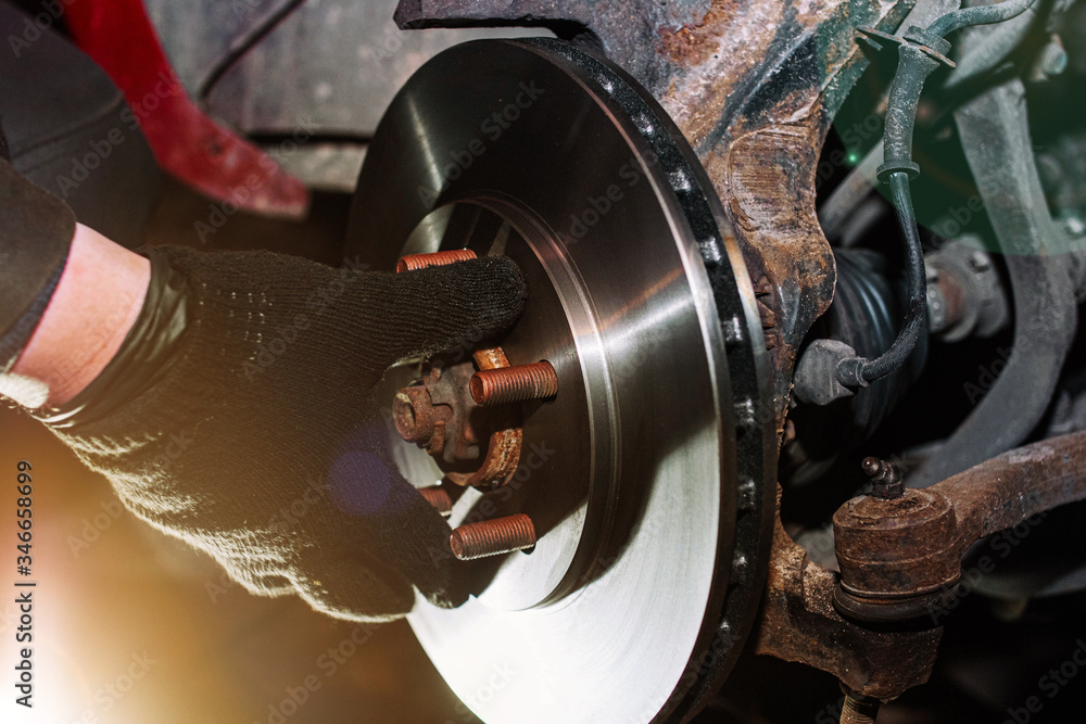 installation of a ventilated brake disc of a car on a hub in a garage ...