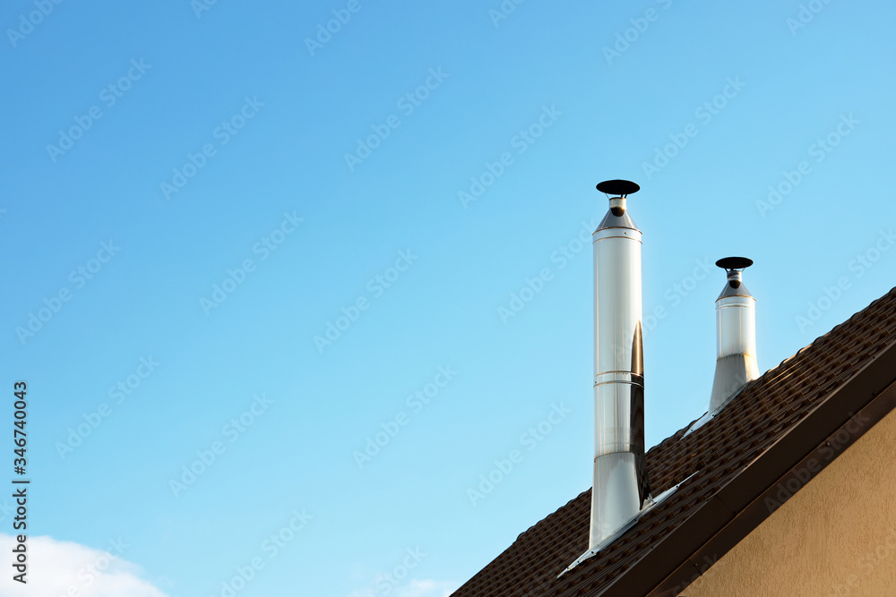 Two modern style chimneys from oven and fireplace stacked stainless ...
