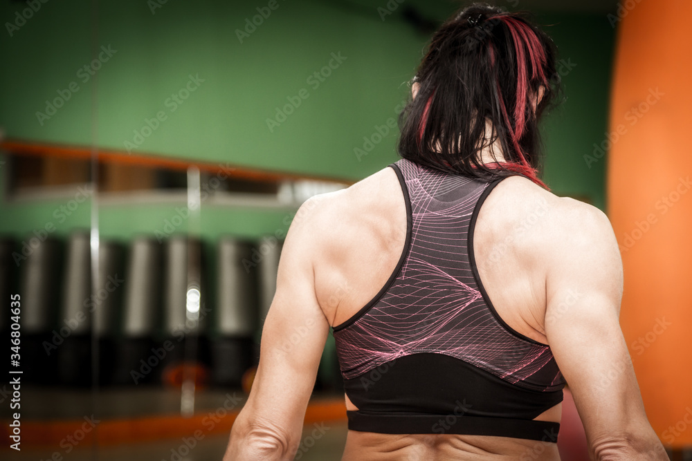 Unrecognizable woman athlete doing exercises with weights and dumbbells ...