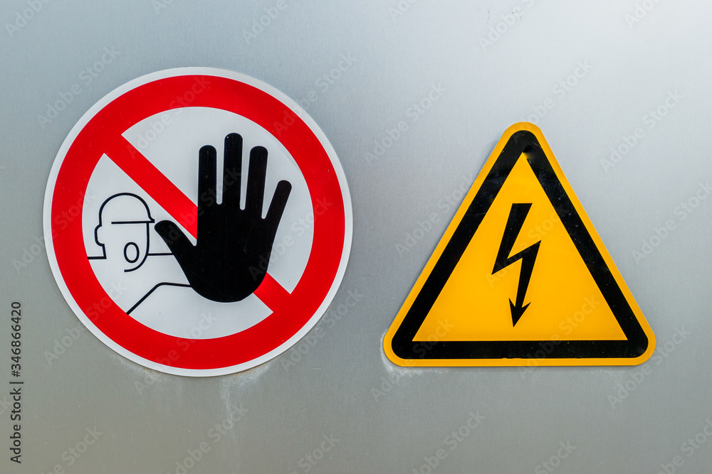 On a giant iron door two warning signs are placed: a round red and ...