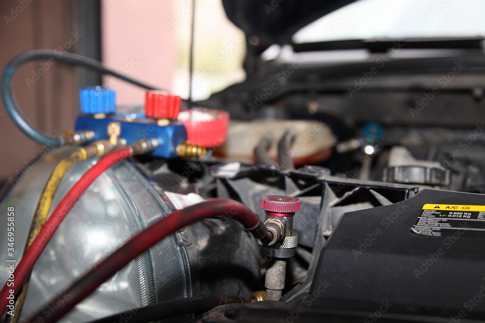 Car A/C high pressure valve on manometers background under the hood of ...