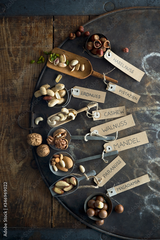 Collection of various nuts with name tags lying on rustic baking sheet ...