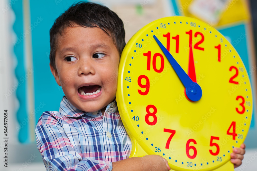 Preschool age boy yelling about what time it is, while holding a big ...