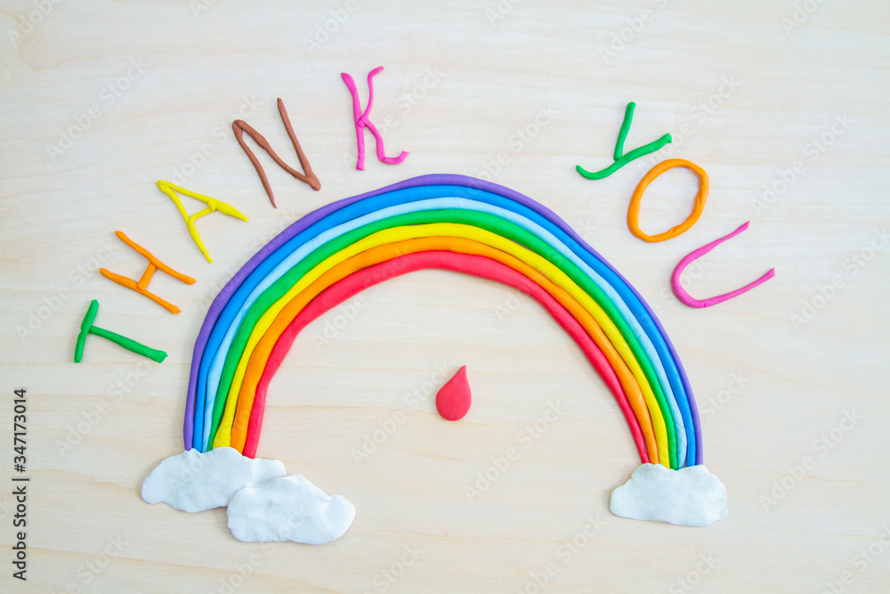 The text "thank you" and a rainbow with white clouds, a drop of ...