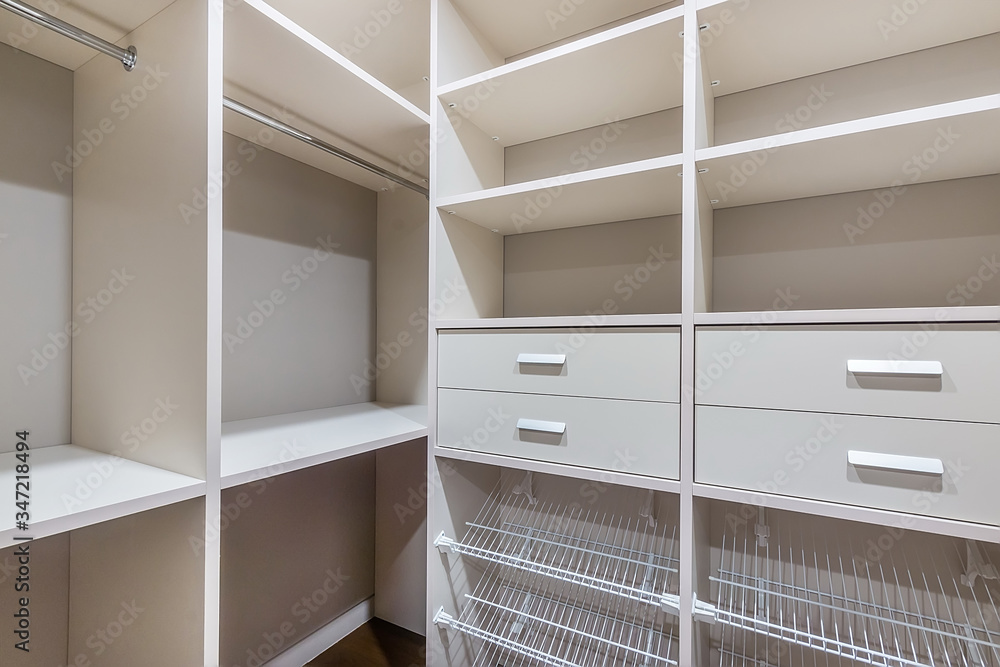 Minimalist white wood walk in closet with wardrobe in neutral beige ...