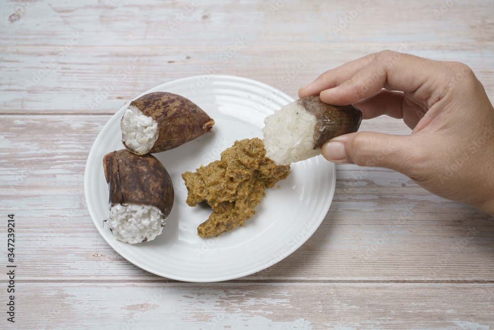 Woman hand holding glutinous rice steamed cooked with coconut milk in ...