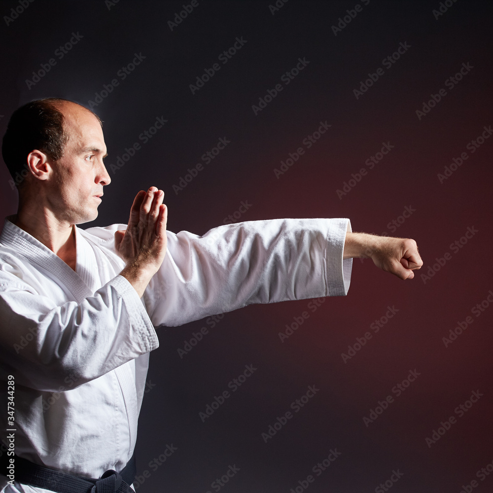 Against a dark red background, a young athlete makes a punch arm Stock ...