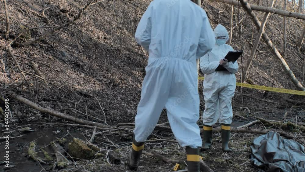 Forensic specialist working in the forest. Police criminalists ...