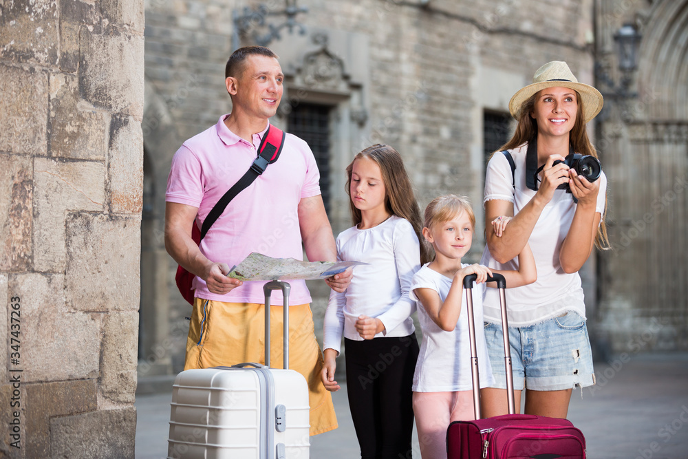 Young parents with children making photo and holding map Stock Photo ...