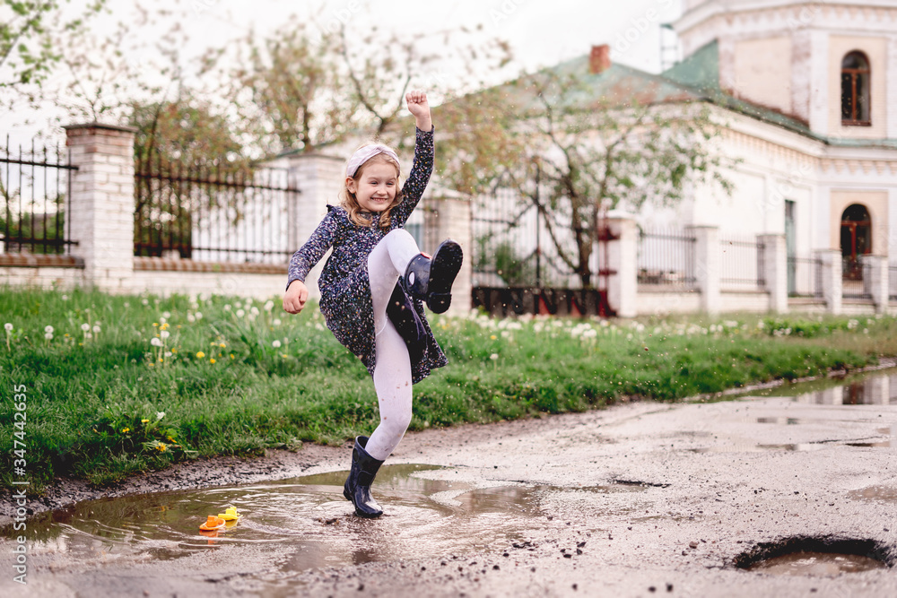girl jumping in a puddle Stock Photo | Adobe Stock