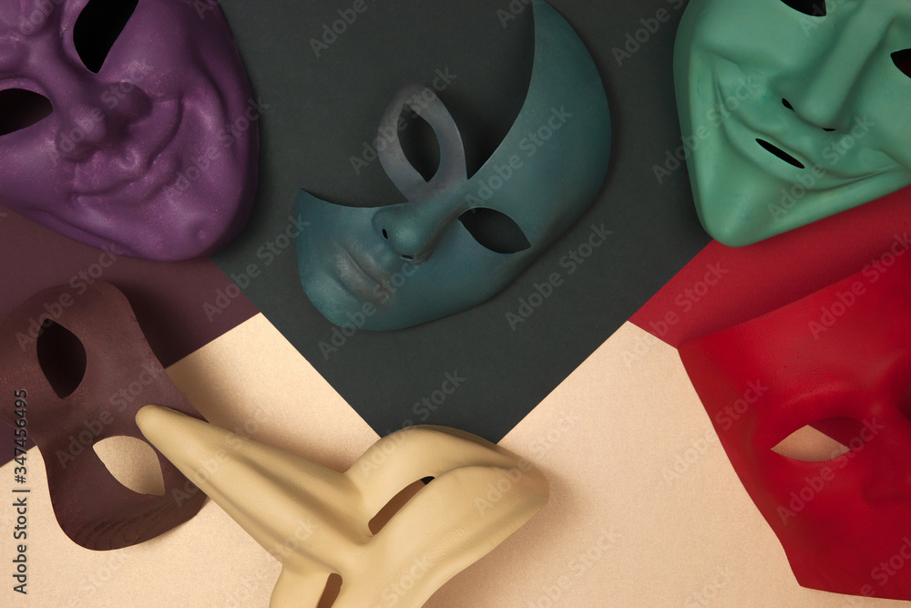Multi-colored venetian masks of different shapes and types on green and ...