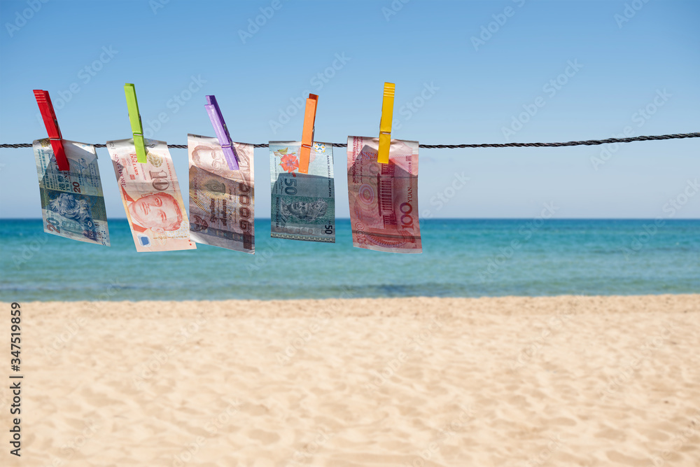 Money of south-east Asia with a clothespin on a rope opposite the sea ...