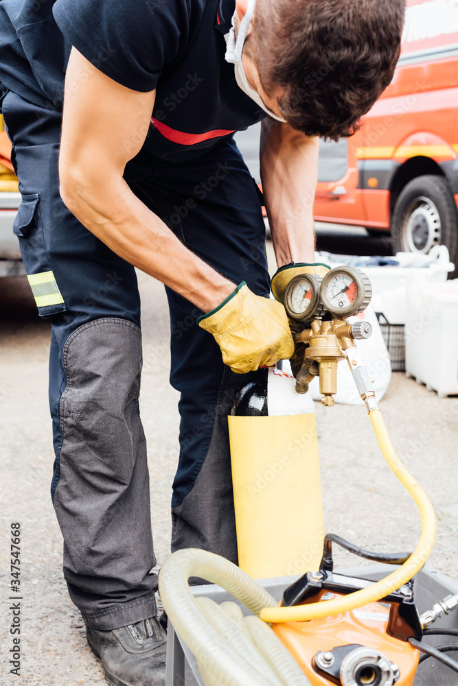 gloved firefighter installs compressed air bottle with manometer Stock ...
