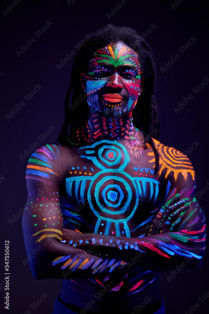 portrait of african man painted in fluorescent paint on face and ...