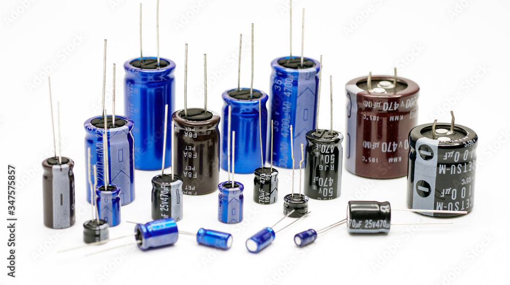 Electrolytic capacitors, many colors and sizes, white background ...