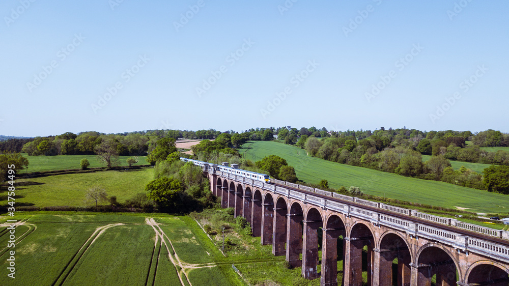 Aerial photo of a viaduct bridge with train passing through in the ...