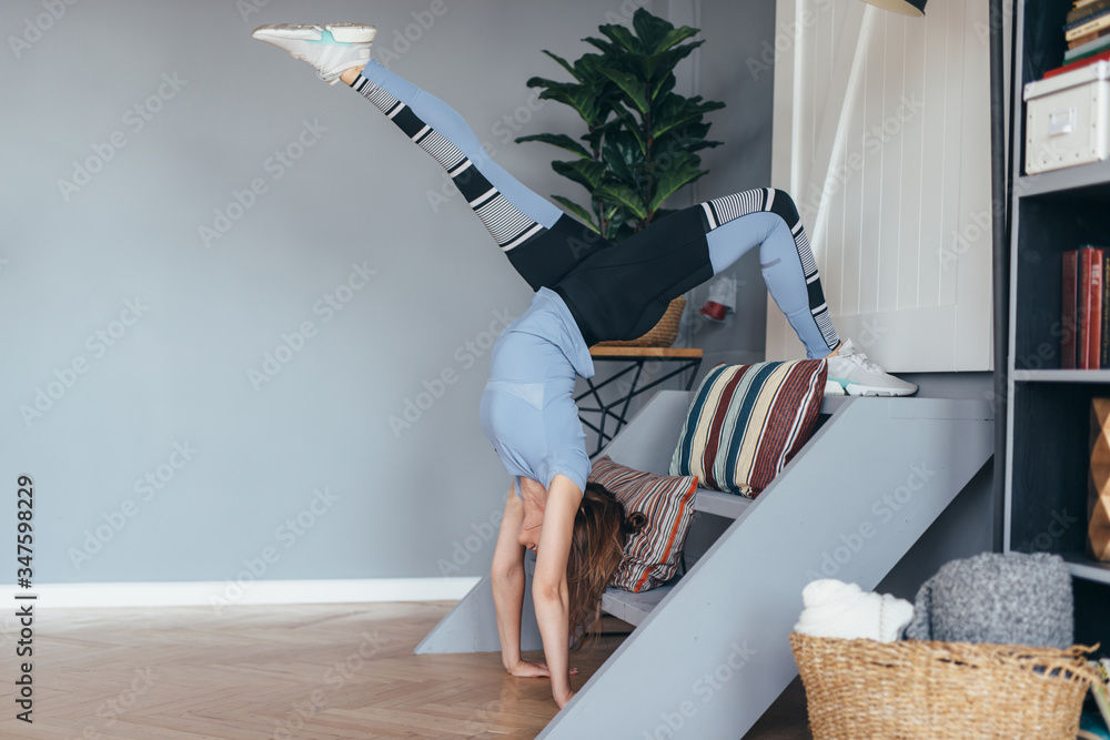 Fitness woman doing backbend stretching exercise at home, working out ...