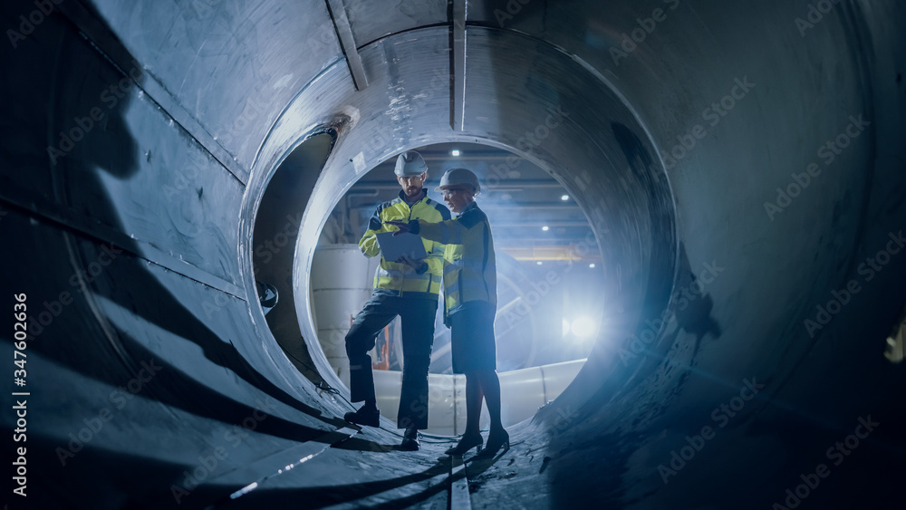 Two Heavy Industry Engineers Walking Inside Pipe, Use Laptop, Have ...