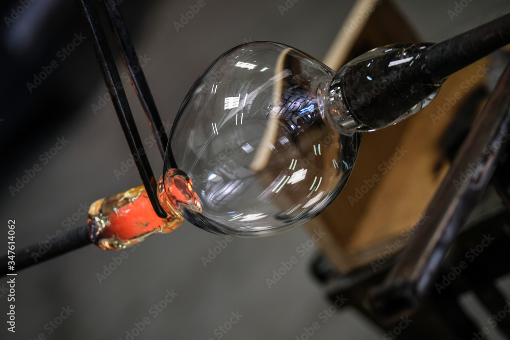 Artist glass blower working glass paste on his workbench. A glass ...