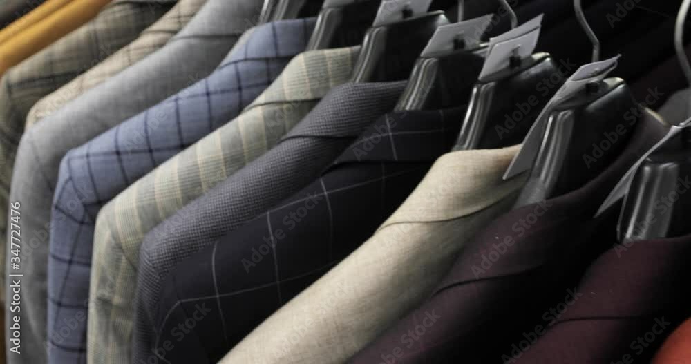 Menswear classical elegant different suits on hangers in row in ...