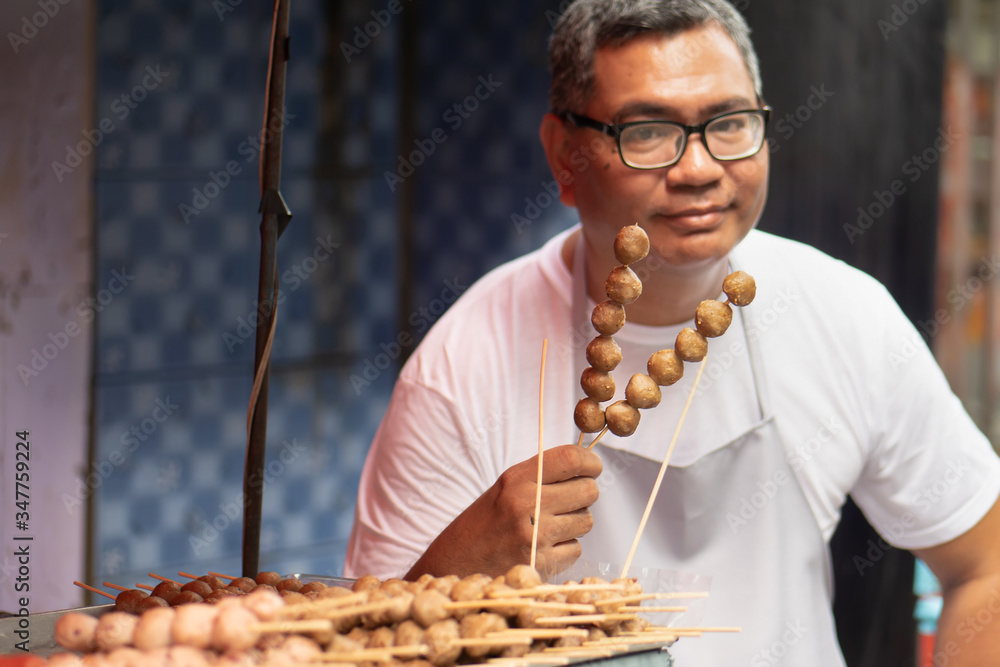 street hawker man working with his delicious meatball skewer street ...