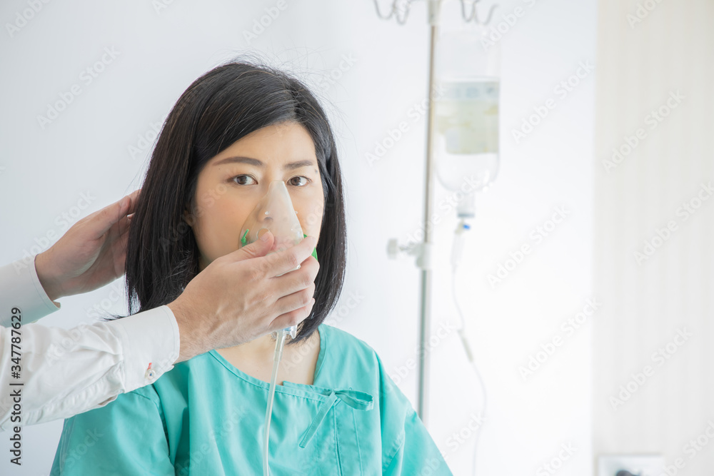 Doctor or nurse putting oxygen mask on a patient. Under going treatment ...