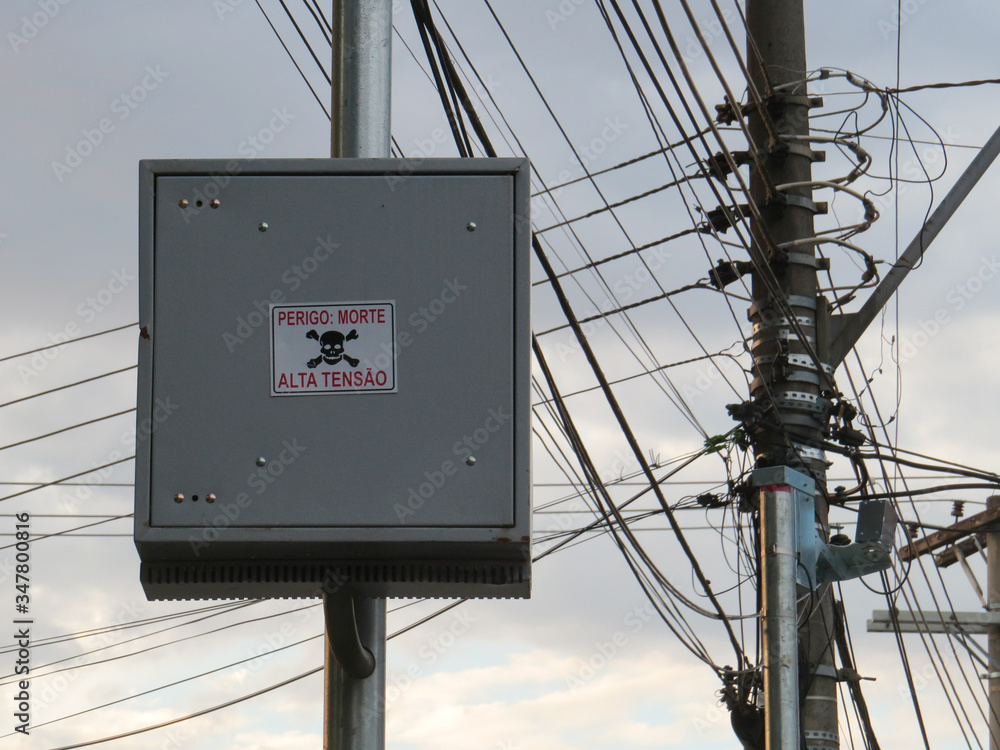 high voltage box with skull and pole with many electrical wires. Translation: Danger: death ...