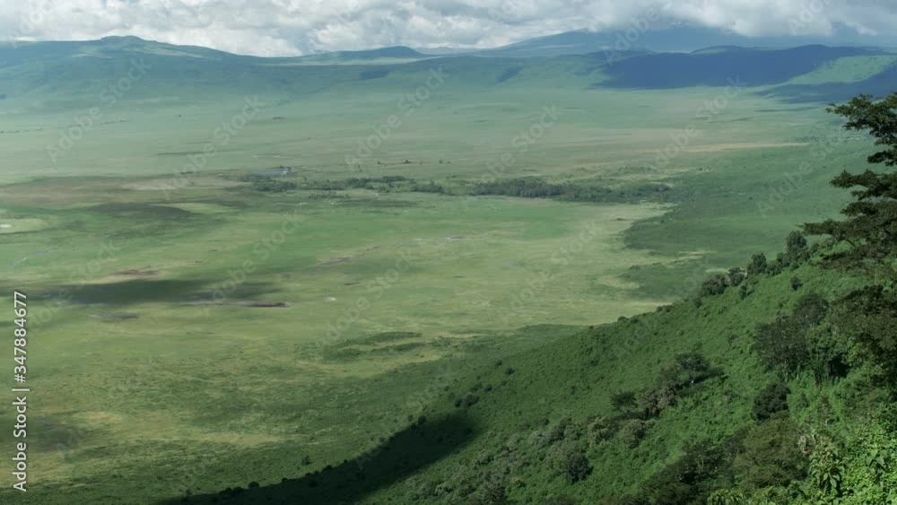 View of the flat green plain. The plain is surrounded by mountains ...